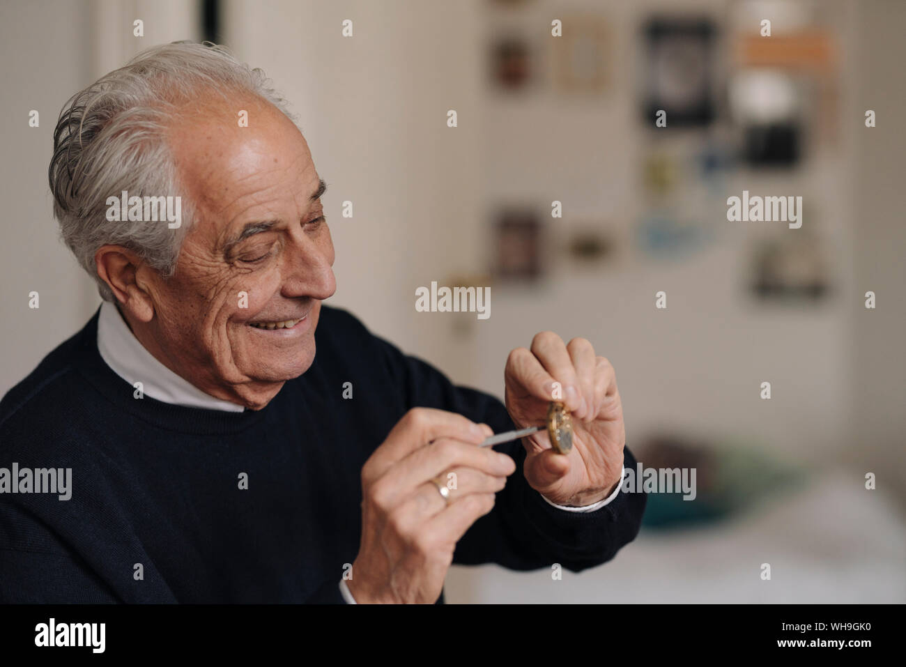 Smiling senior man repairing a watch at home Stock Photo - Alamy