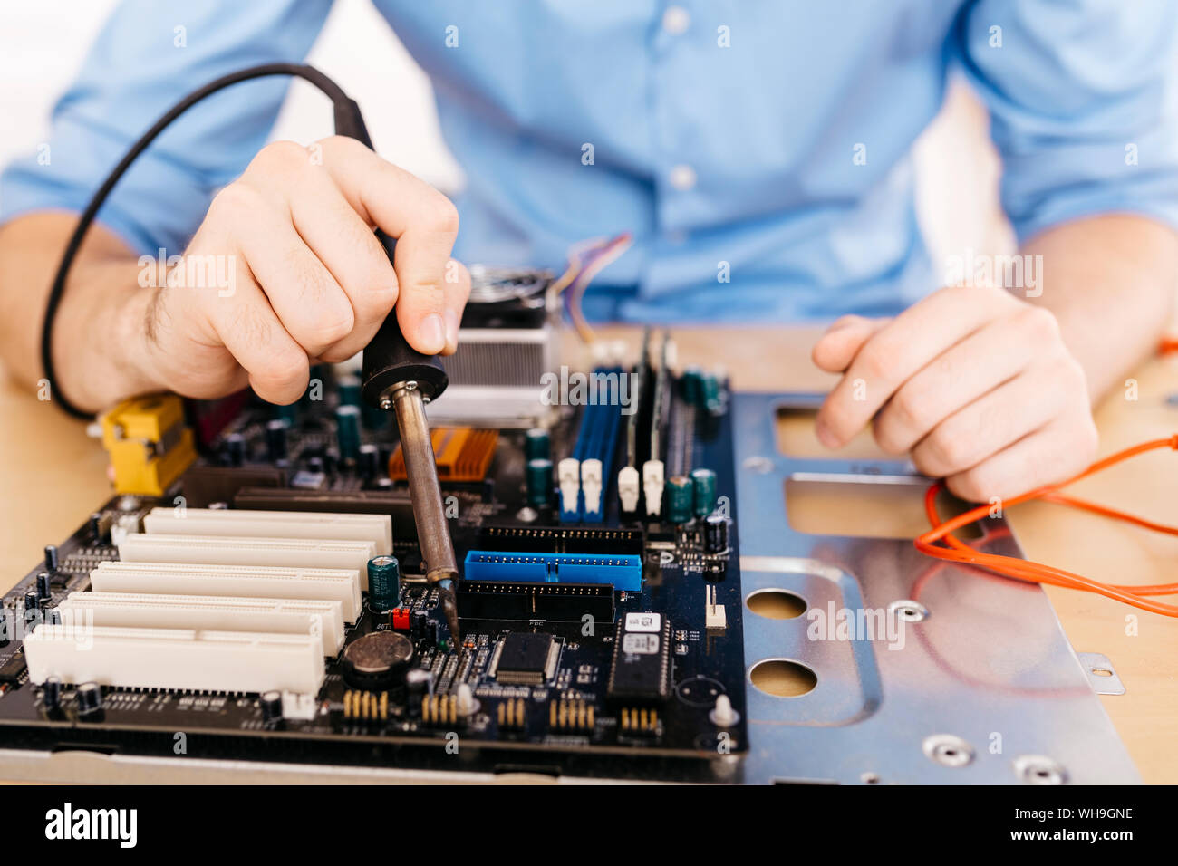 Close-up of technician repairing a desktop computer, soldering a ...