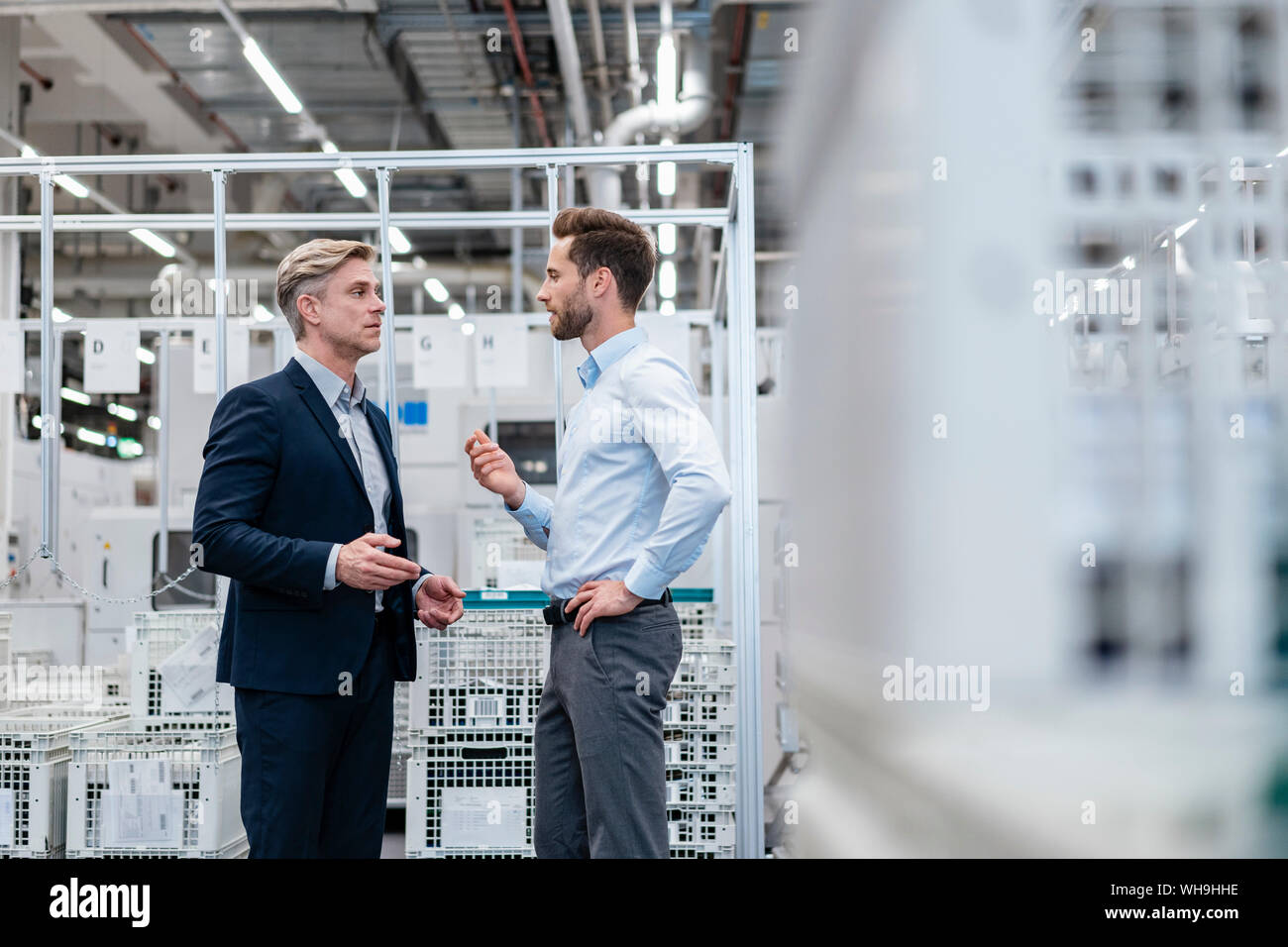 Two businessmen talking in a modern factory Stock Photo - Alamy