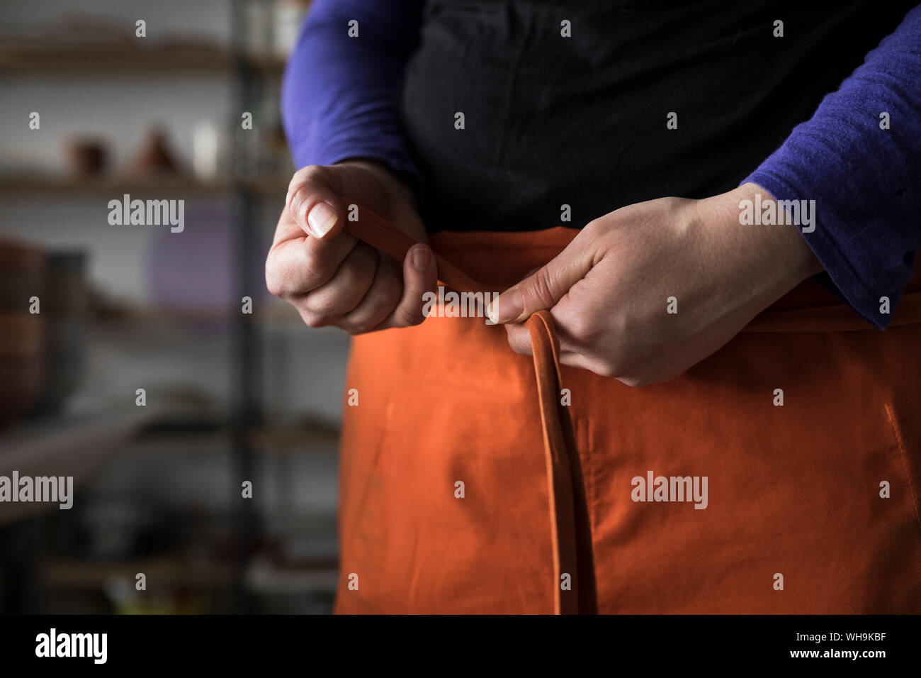 Woman's hands tying apron Stock Photo - Alamy