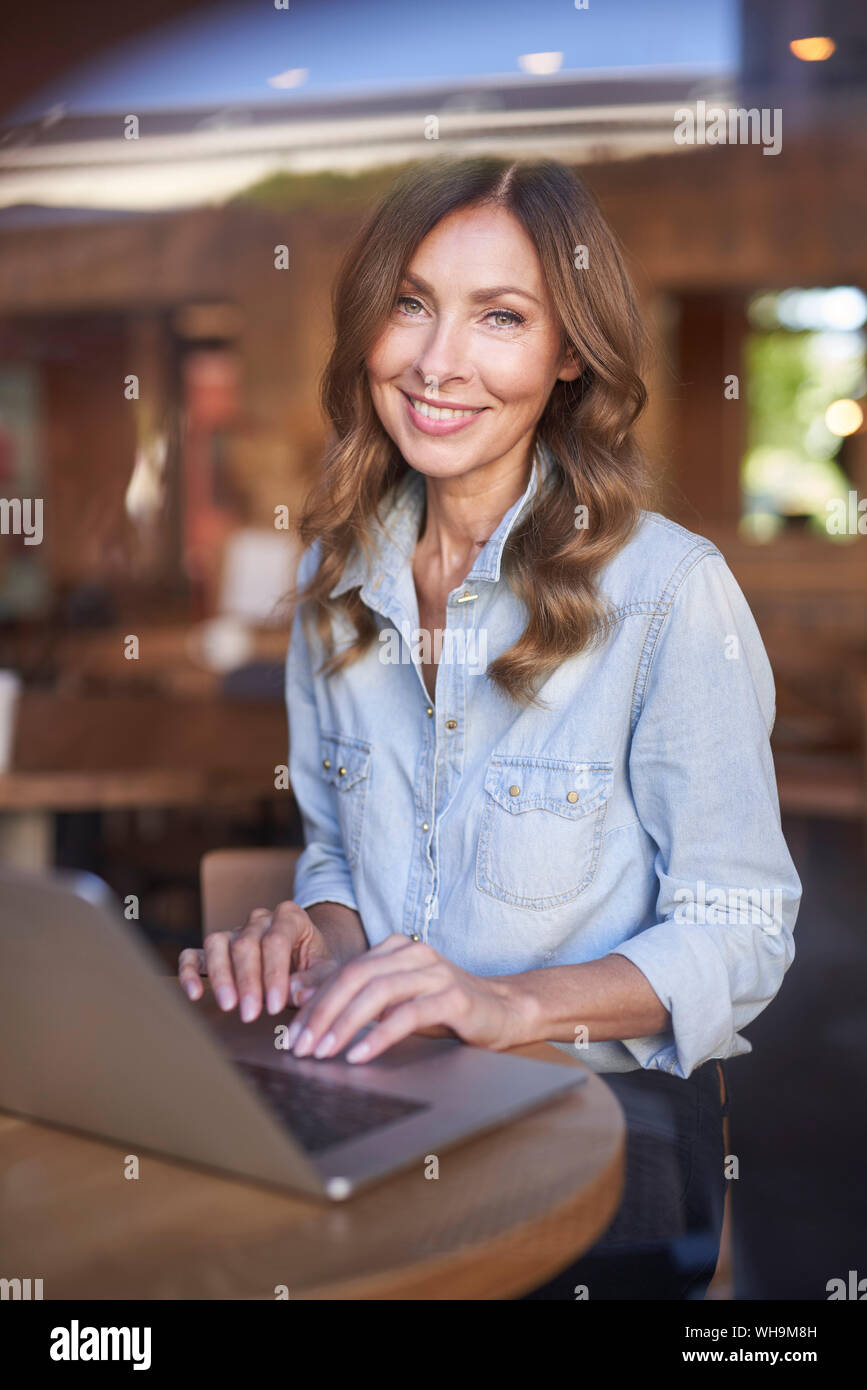 Business woman using laptop in a cafe Stock Photo - Alamy