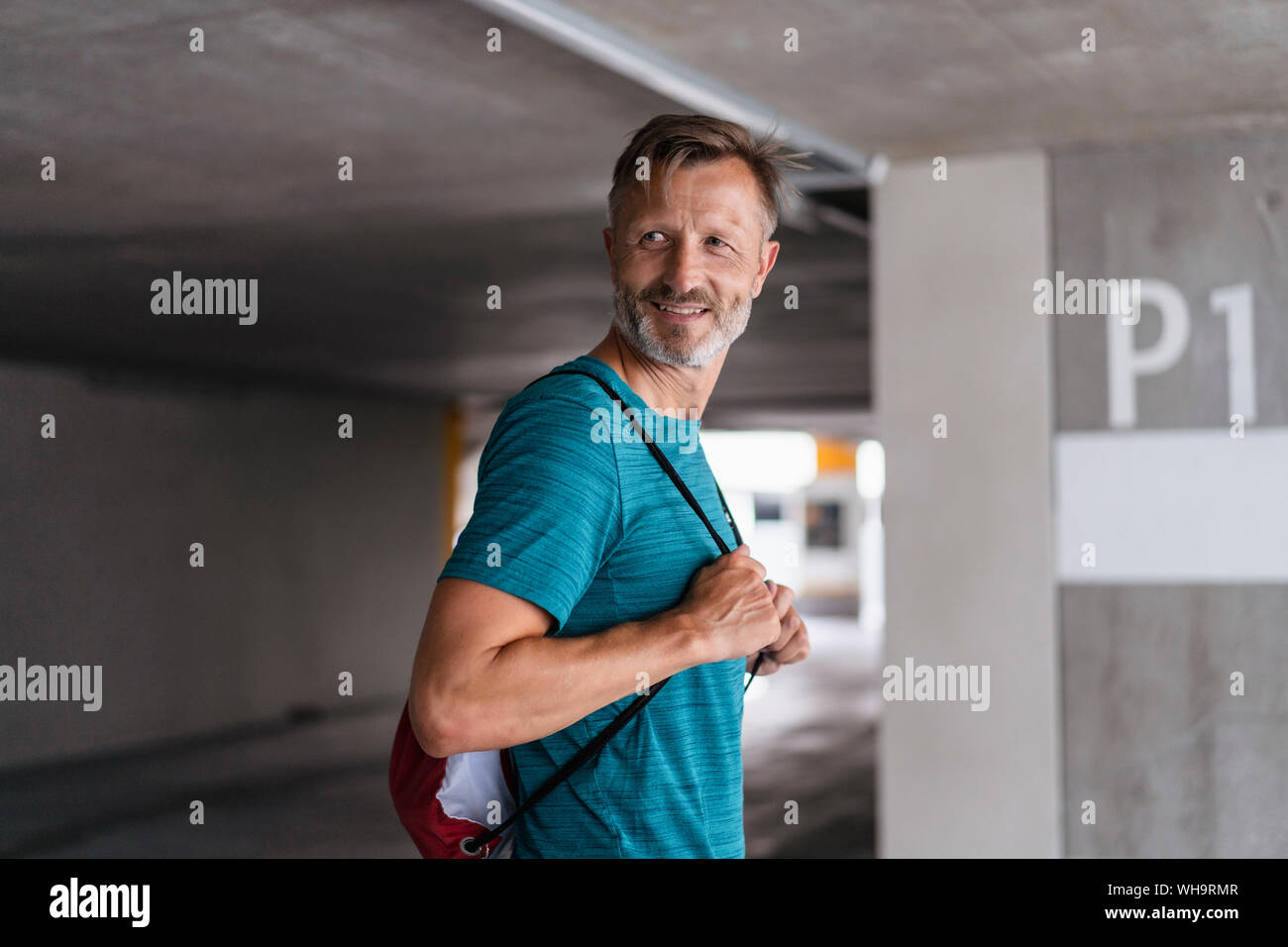 Portrait of a sporty man carrying a pouch Stock Photo - Alamy