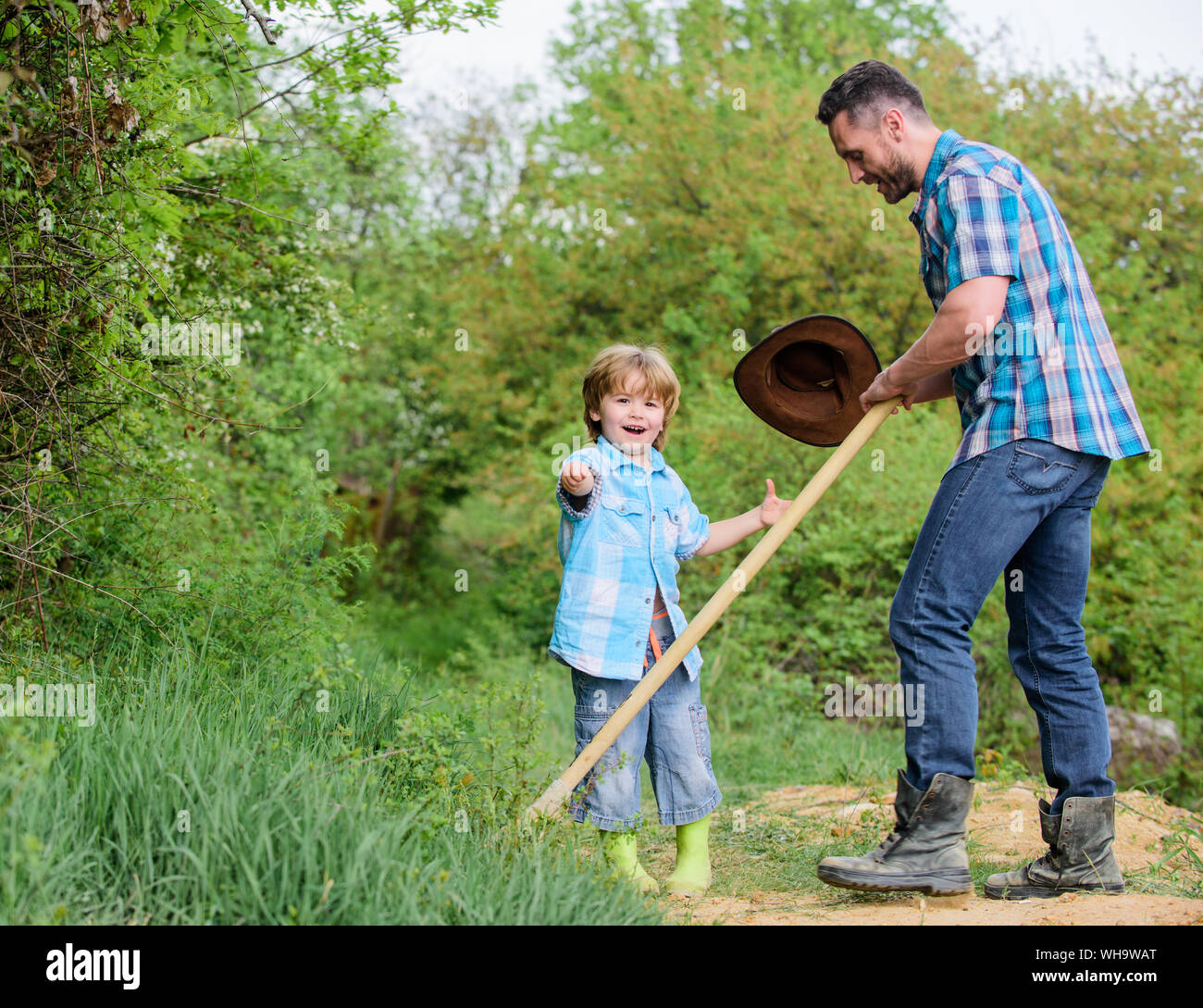 Little helper in garden. Child having fun cowboy dad. Farm family ...