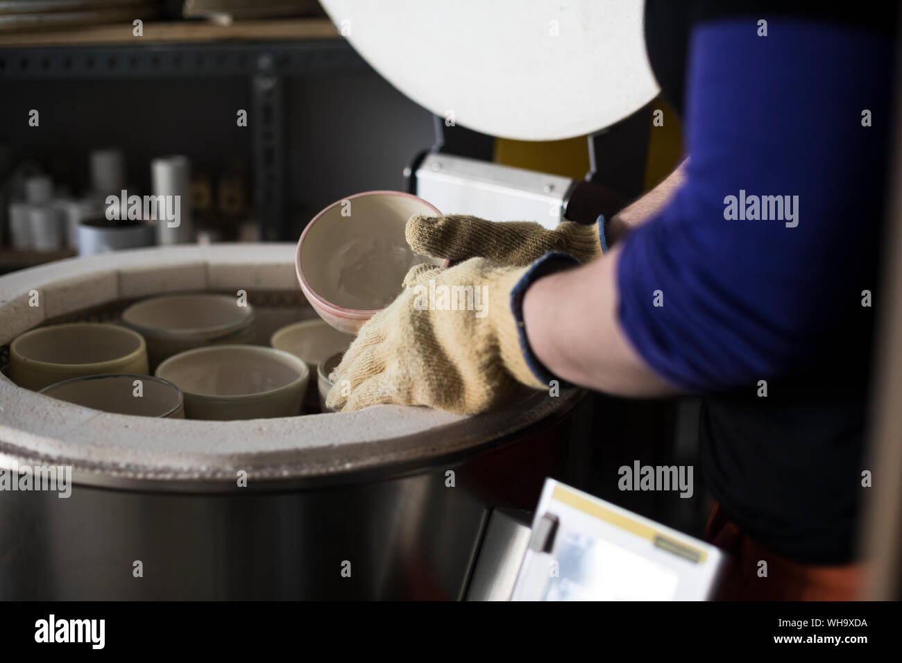Potter putting pots in kiln Stock Photo - Alamy