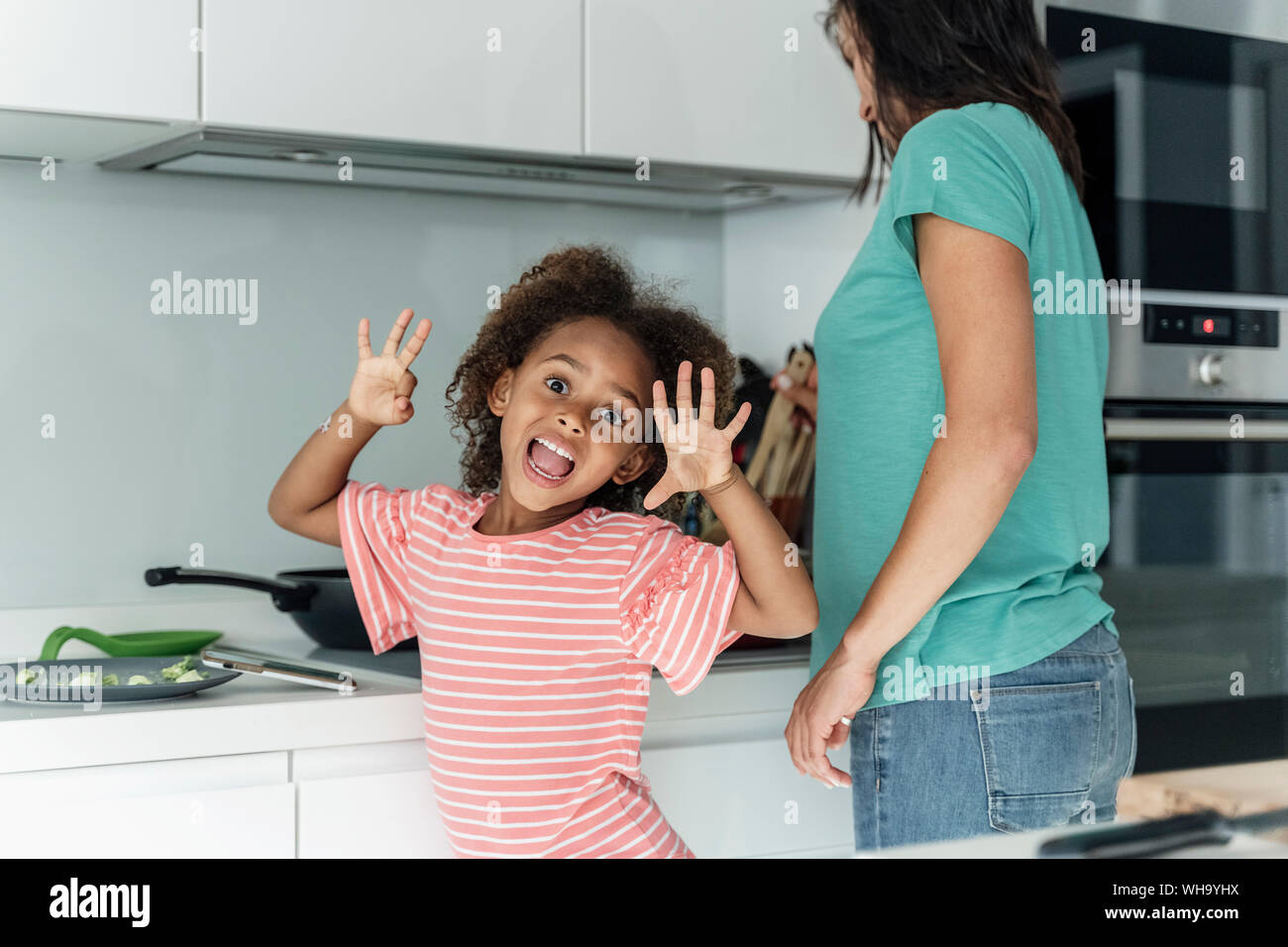 Portrait of happy girl cooking with mother in kitchen Stock Photo - Alamy