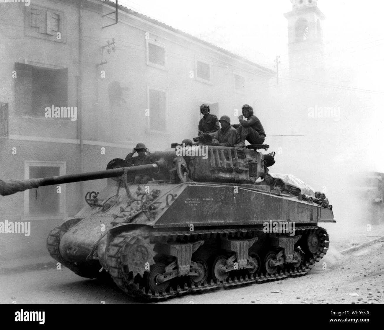 WW2: A tank and vehicles of the US Fifth Army move through a town in ...