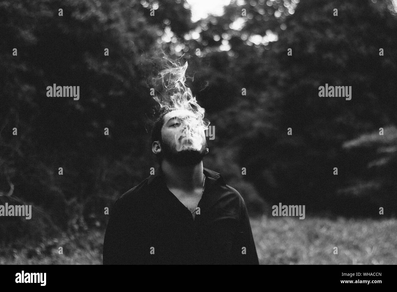 Against tree smoking cigarette hi-res stock photography and images - Alamy