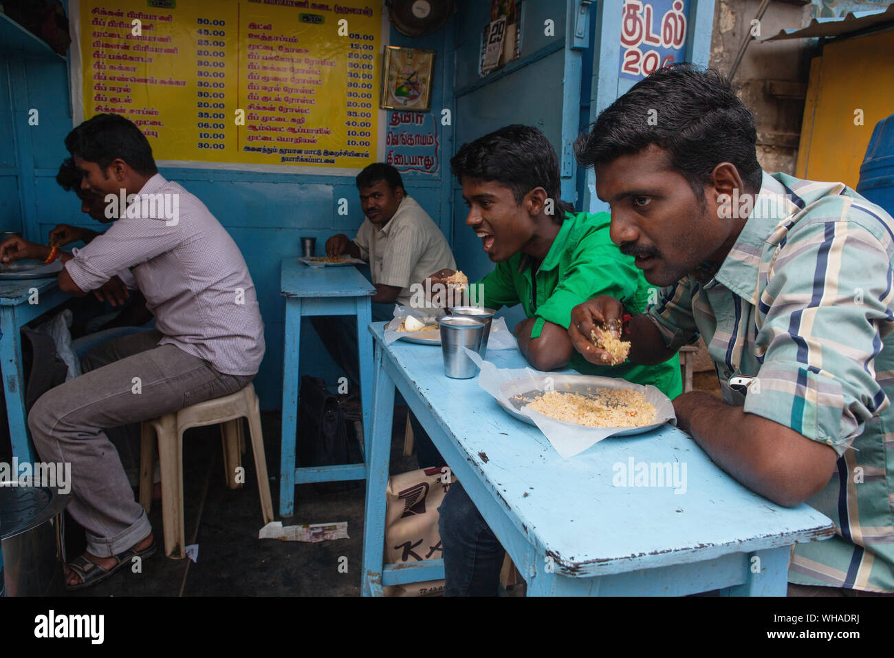 India, Tamil Nadu, Madurai, Men eating rice biryani at a food shack in ...