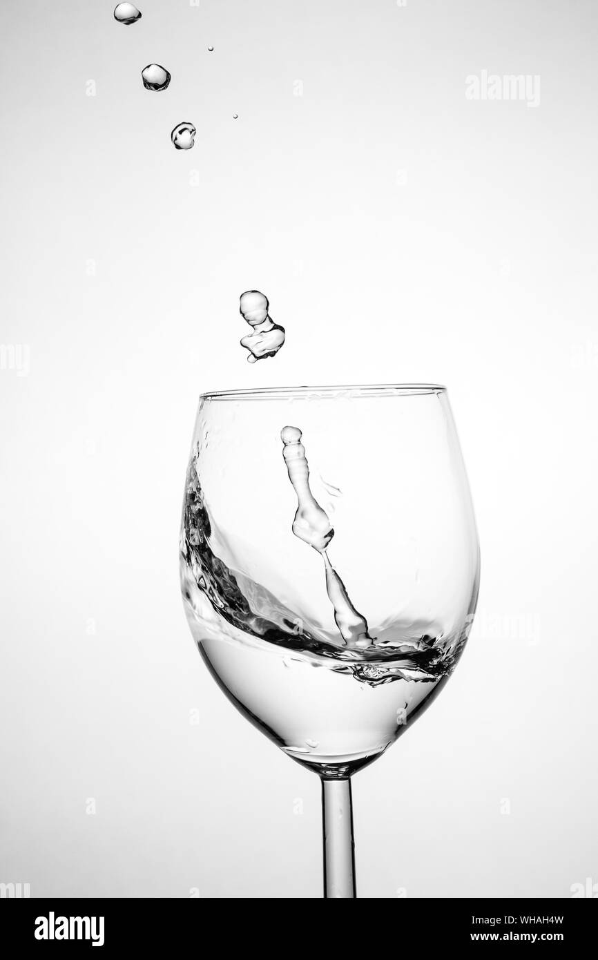 Glass with water up and splash Stock Photo - Alamy
