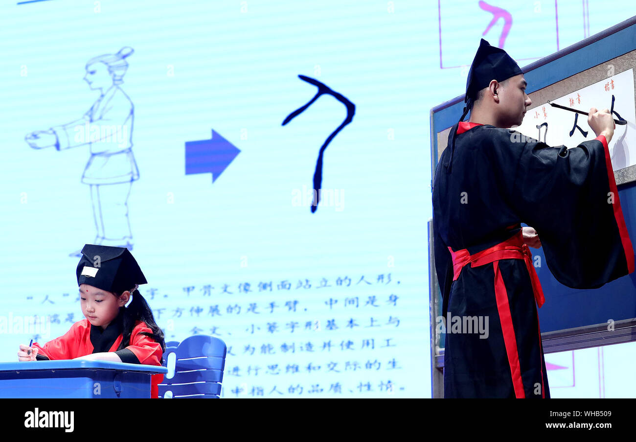 Shanghai, China. 2nd Sep, 2019. A teacher (R) demonstrates how to write ...