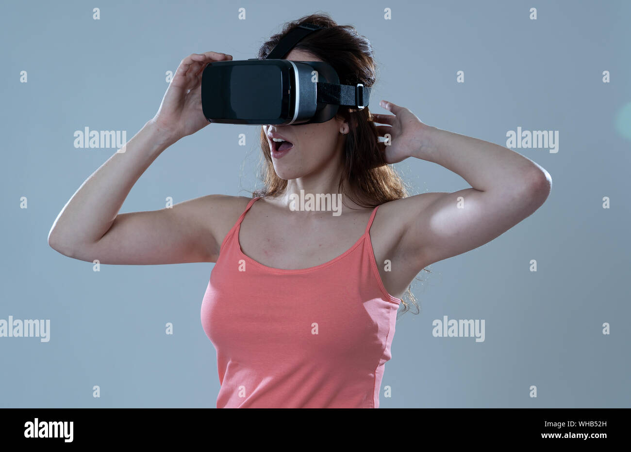 Curious woman happy and excited to use virtual reality goggles feeling ...