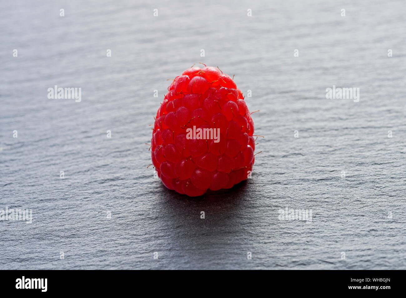Closeup view of a raspberry over a blackboard plate Stock Photo - Alamy