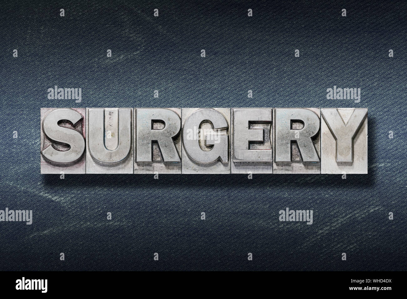 surgery word made from metallic letterpress on dark jeans background ...