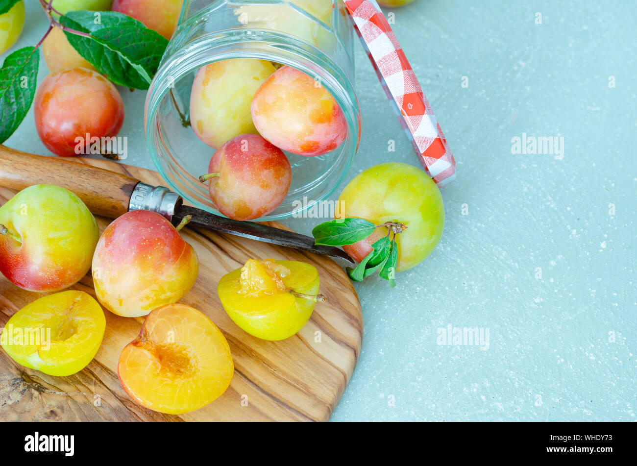 Fresh cut plums on kitchen board and blue background. Fresh fruit Stock ...