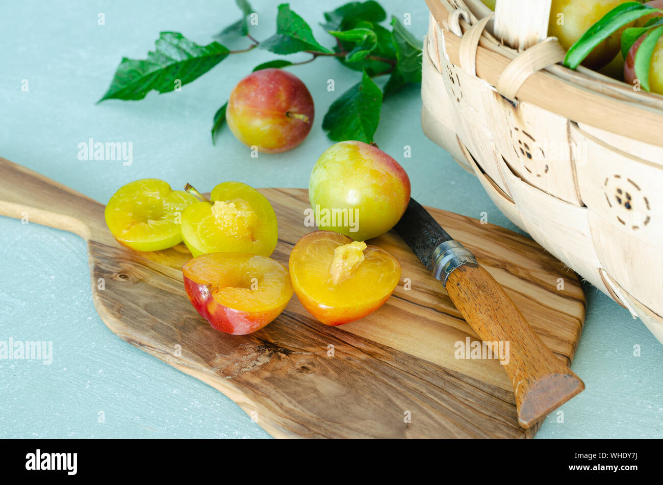 Fresh cut plums on kitchen board and blue background. Fresh fruit Stock ...