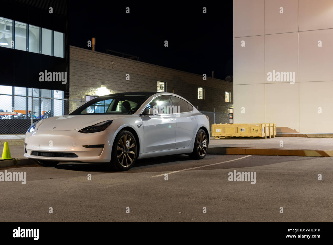 Tesla Model 3 parked at the back of a Tesla Dealership at night Stock ...