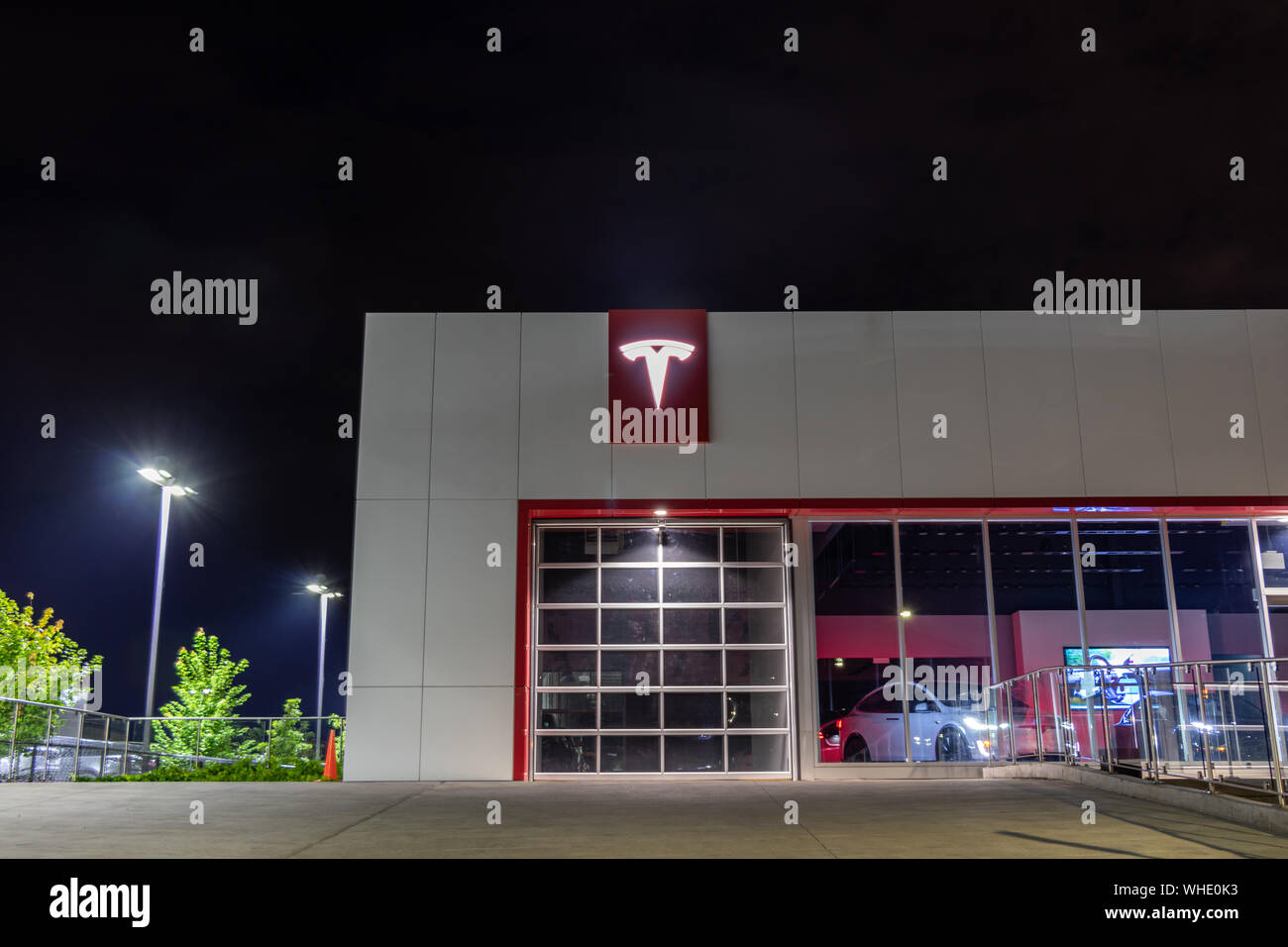 Tesla logo illuminated atop of a Tesla Dealership at night Stock Photo ...