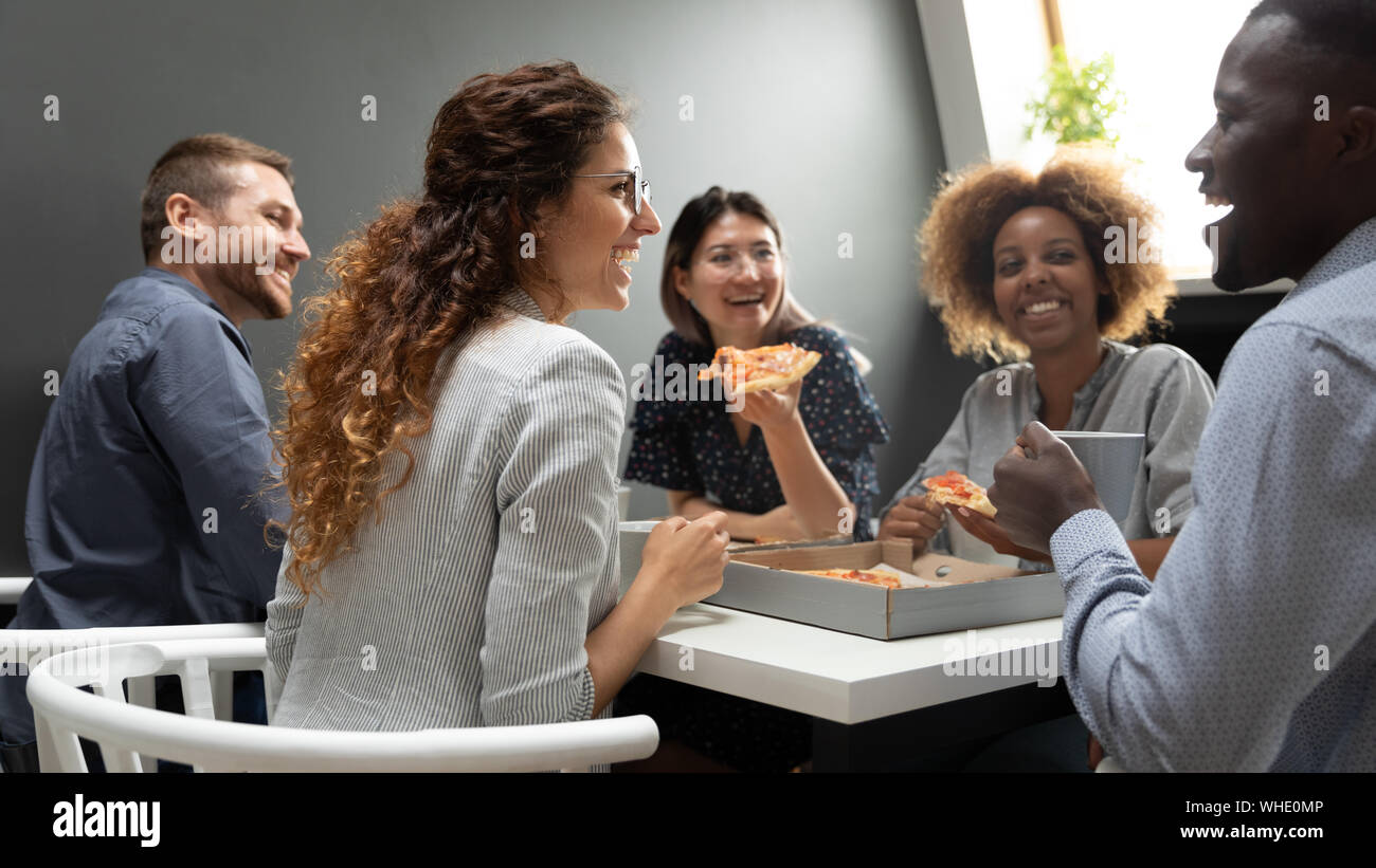 Cheerful multiracial business team people having fun eating pizza ...