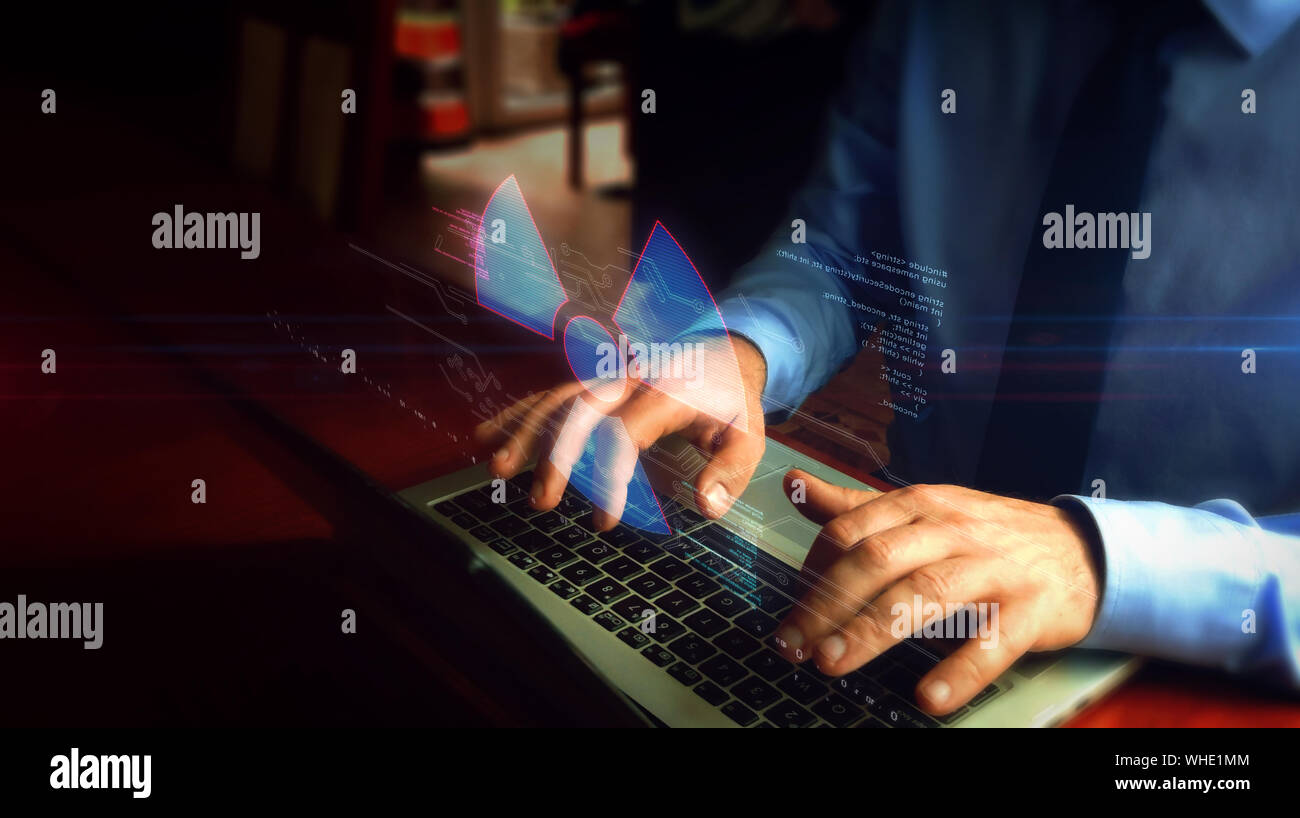 Man typing on laptop with nuclear energy symbol hologram screen over ...