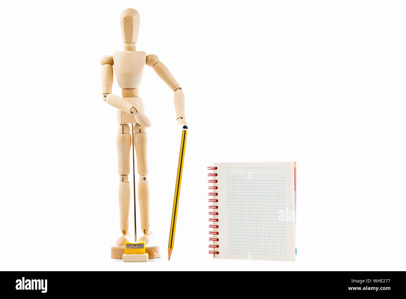 Wooden toy figure with pencil and notebook on white background Stock ...