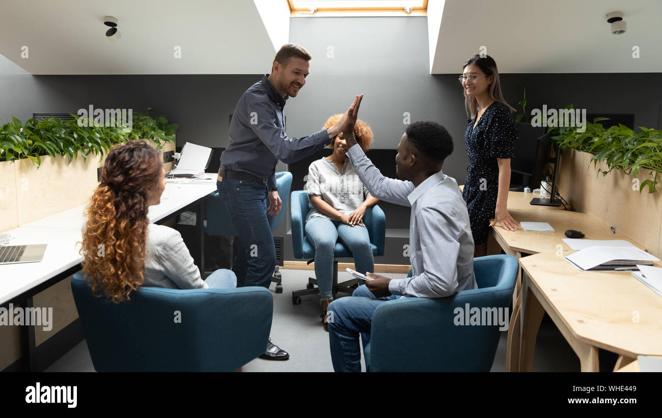 Happy caucasian leader give high five african employee at meeting Stock ...