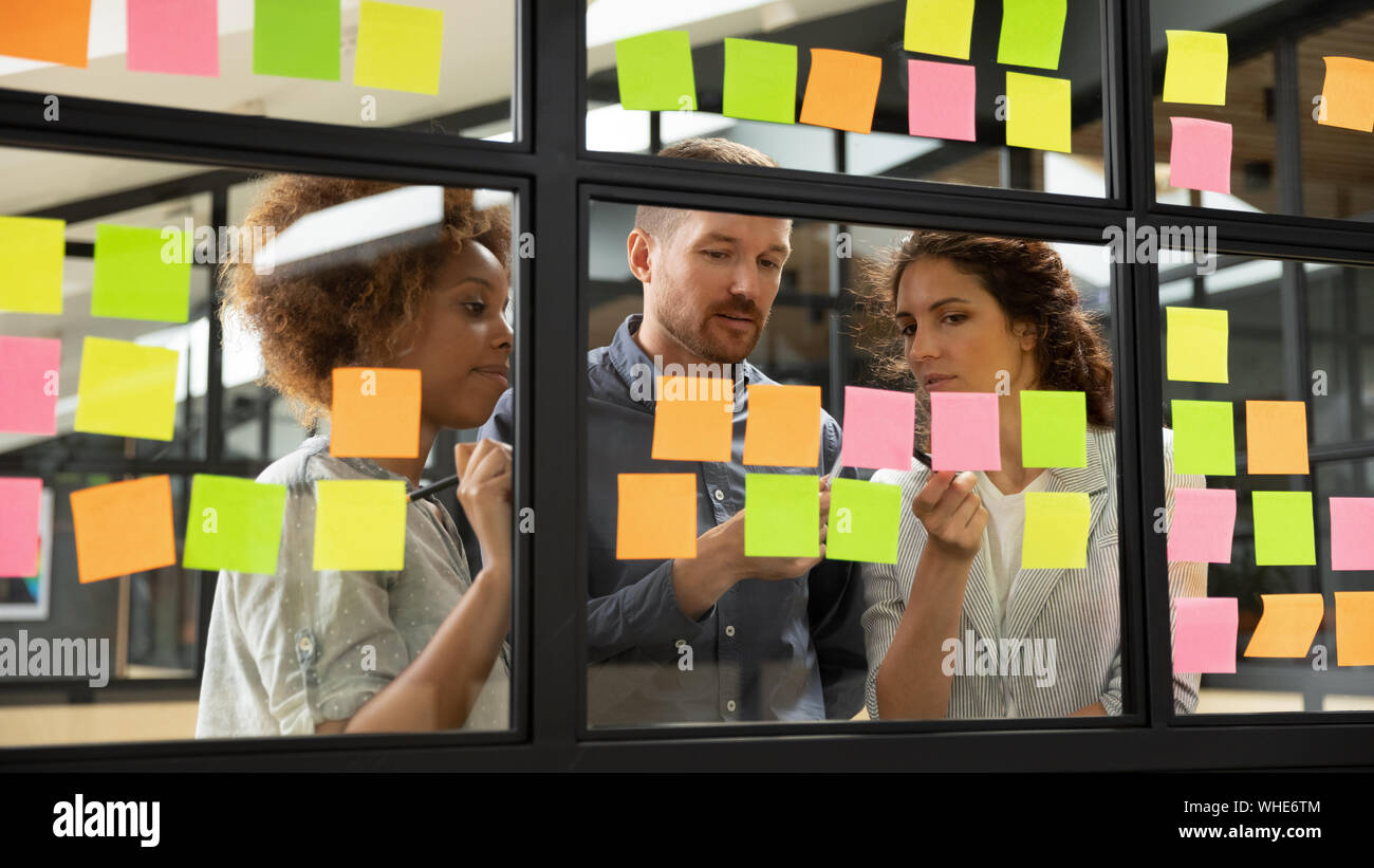 Diverse business team brainstorm on project strategy with sticky notes ...