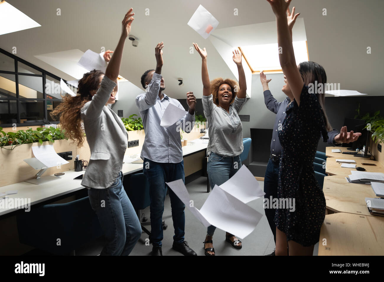 Happy multiethnic business team throwing tossing papers in office Stock ...