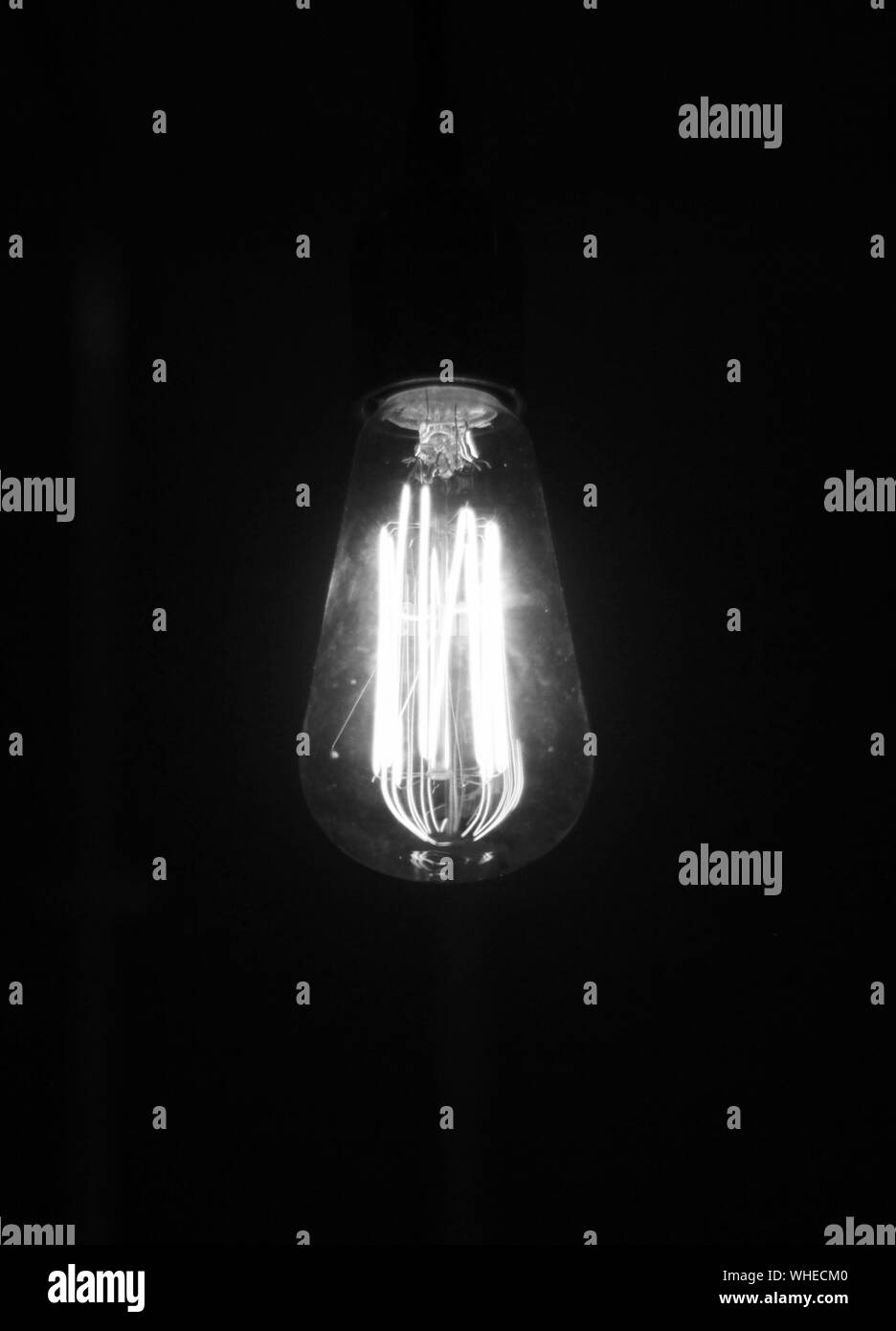 Light bulb over black background Black and White Stock Photos & Images ...