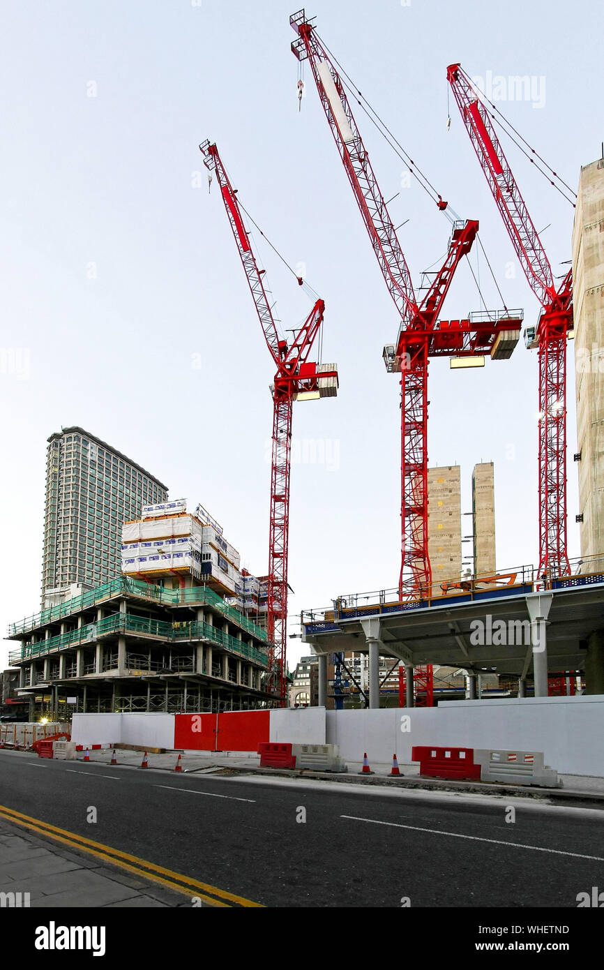 Tree tall red cranes and construction site Stock Photo - Alamy