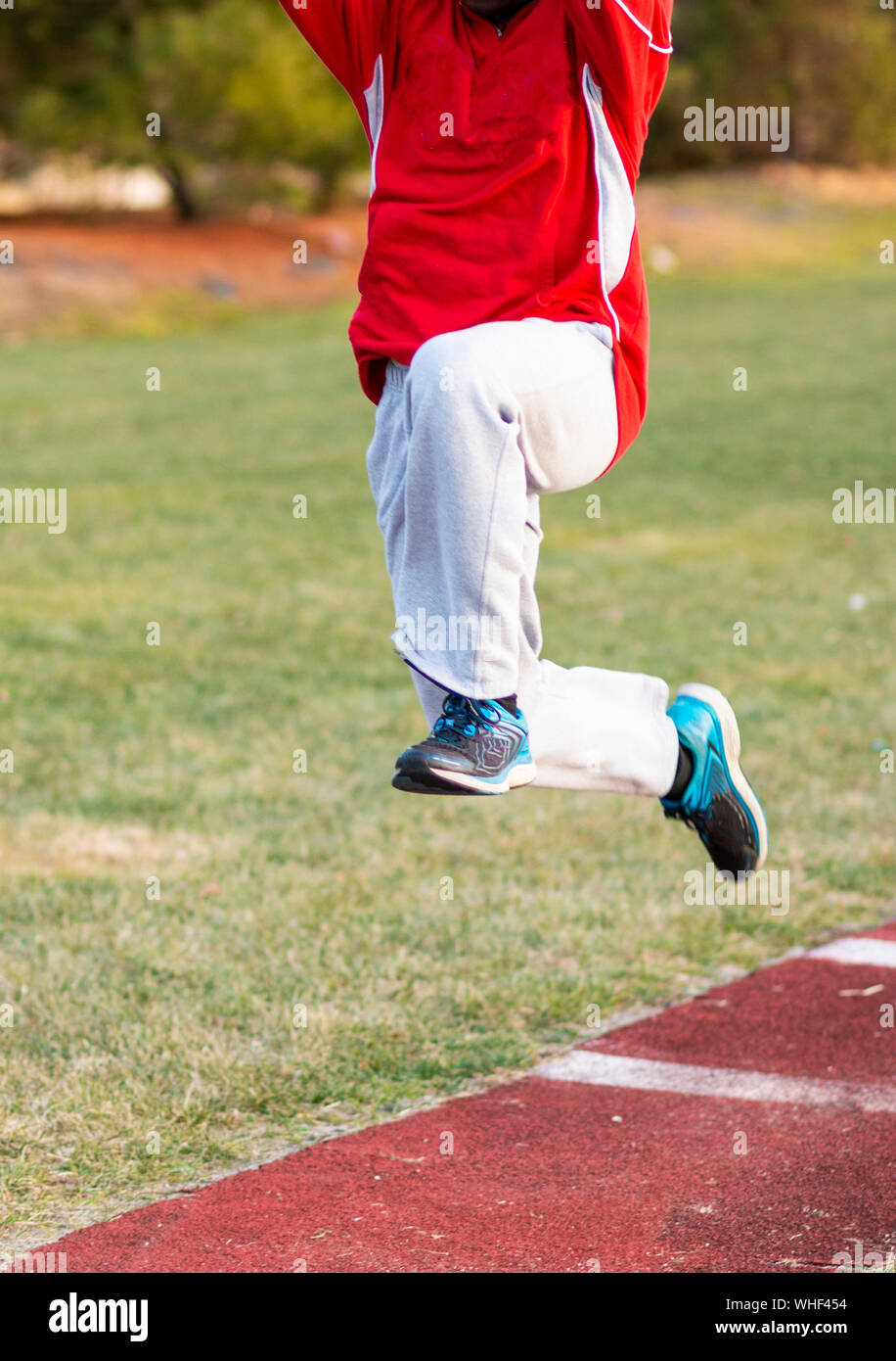 An african american high school boy is practicing the hop, skip and ...