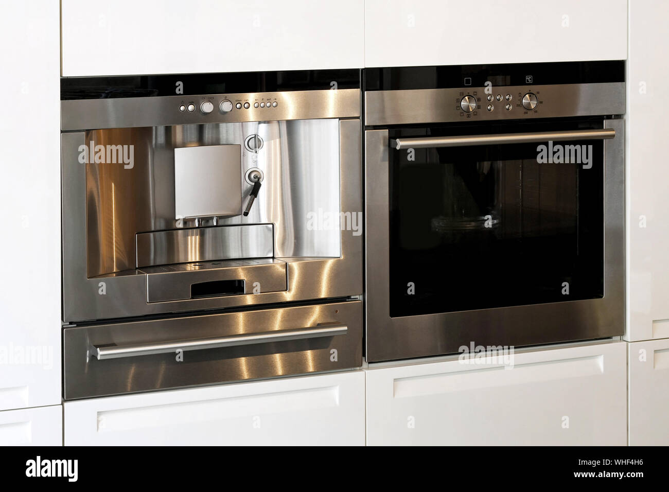 Silver coffee machine and oven in kitchen Stock Photo - Alamy
