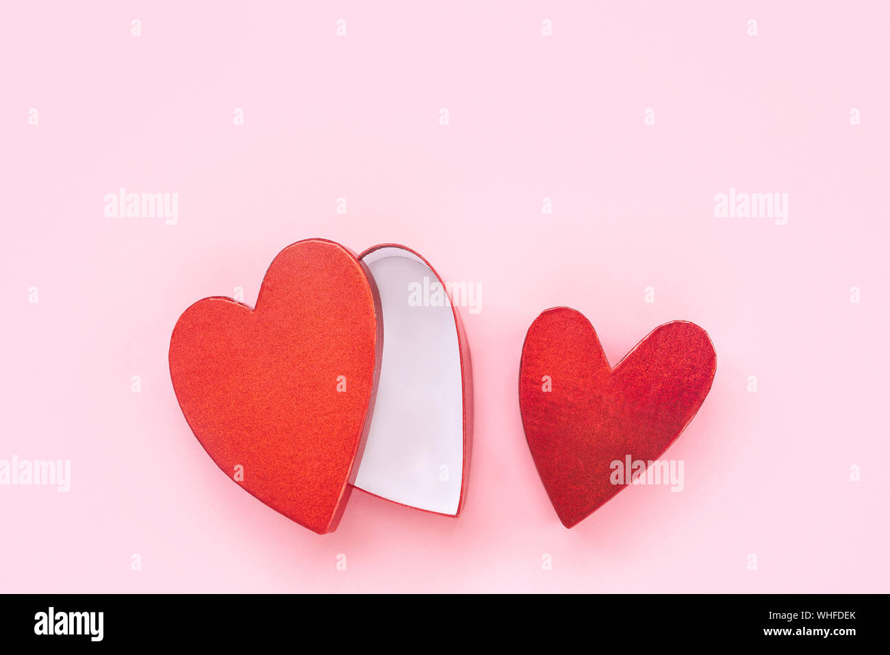 Tow red heart-shaped gift boxes on a pink background Stock Photo - Alamy