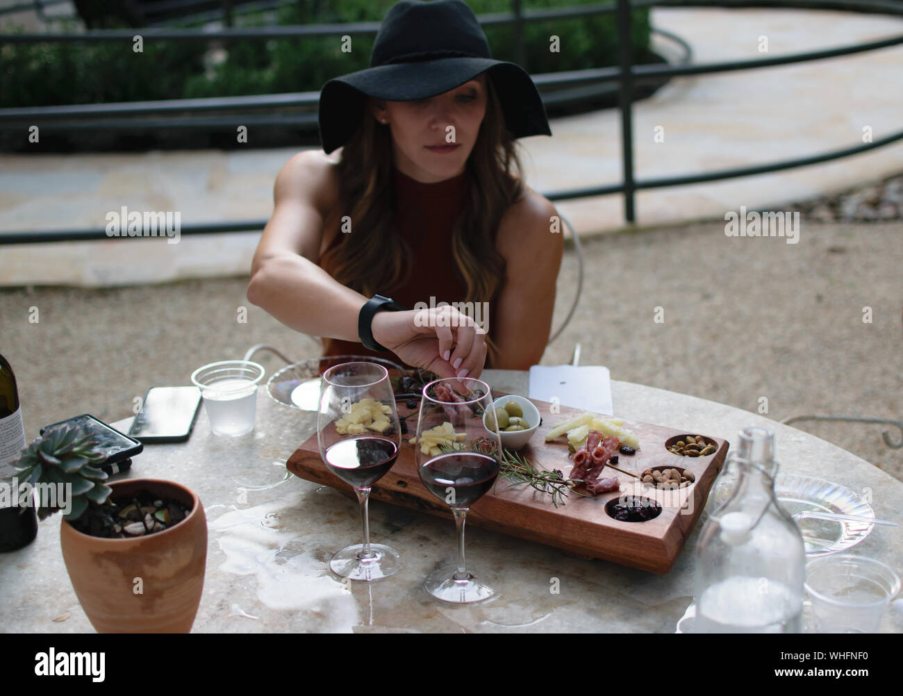Trendy Female Model Eating Meat and Cheese Board with WIne in ...