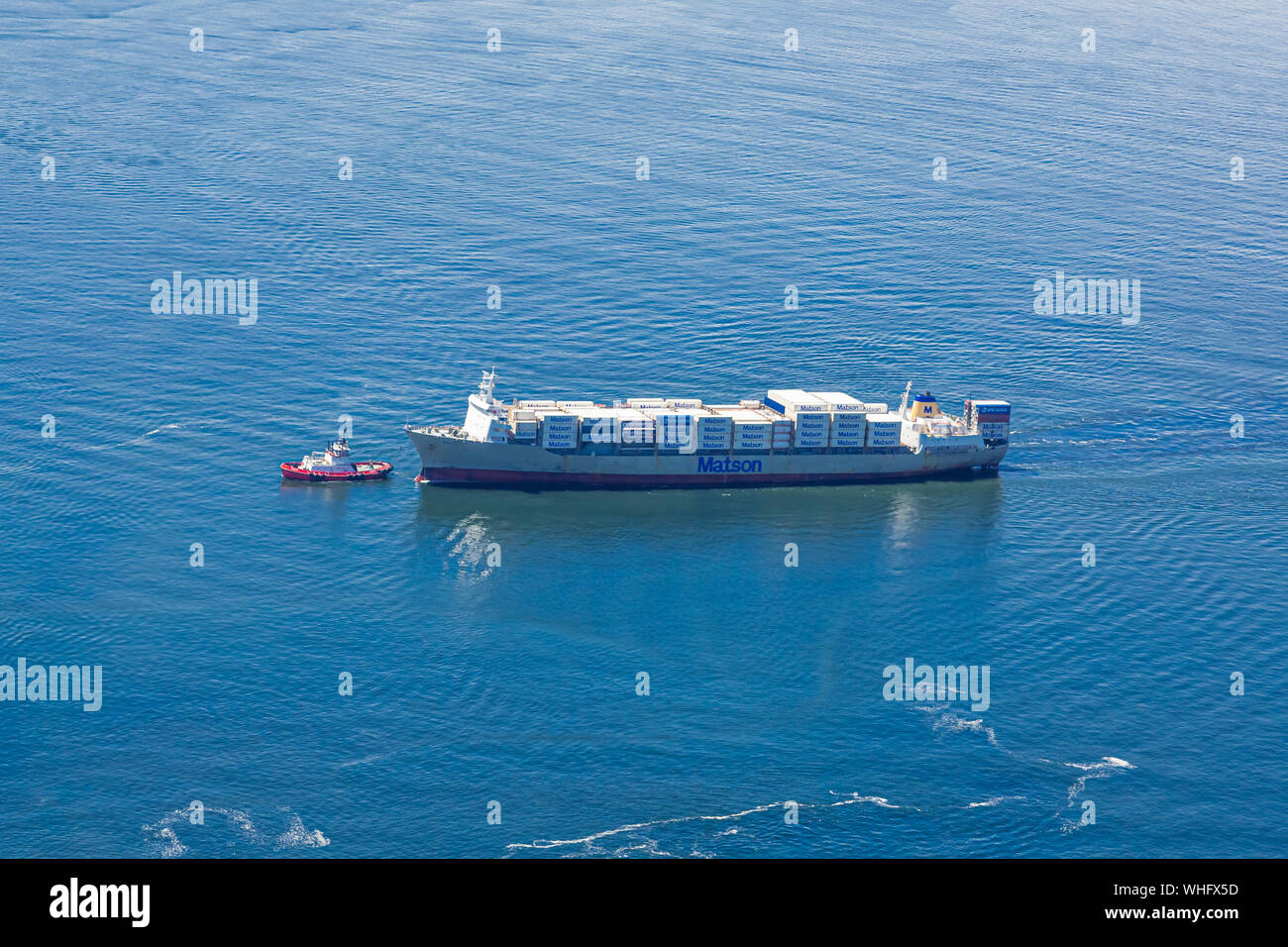 A tugboat pulling a massive freighter through Puget Sound Stock Photo ...