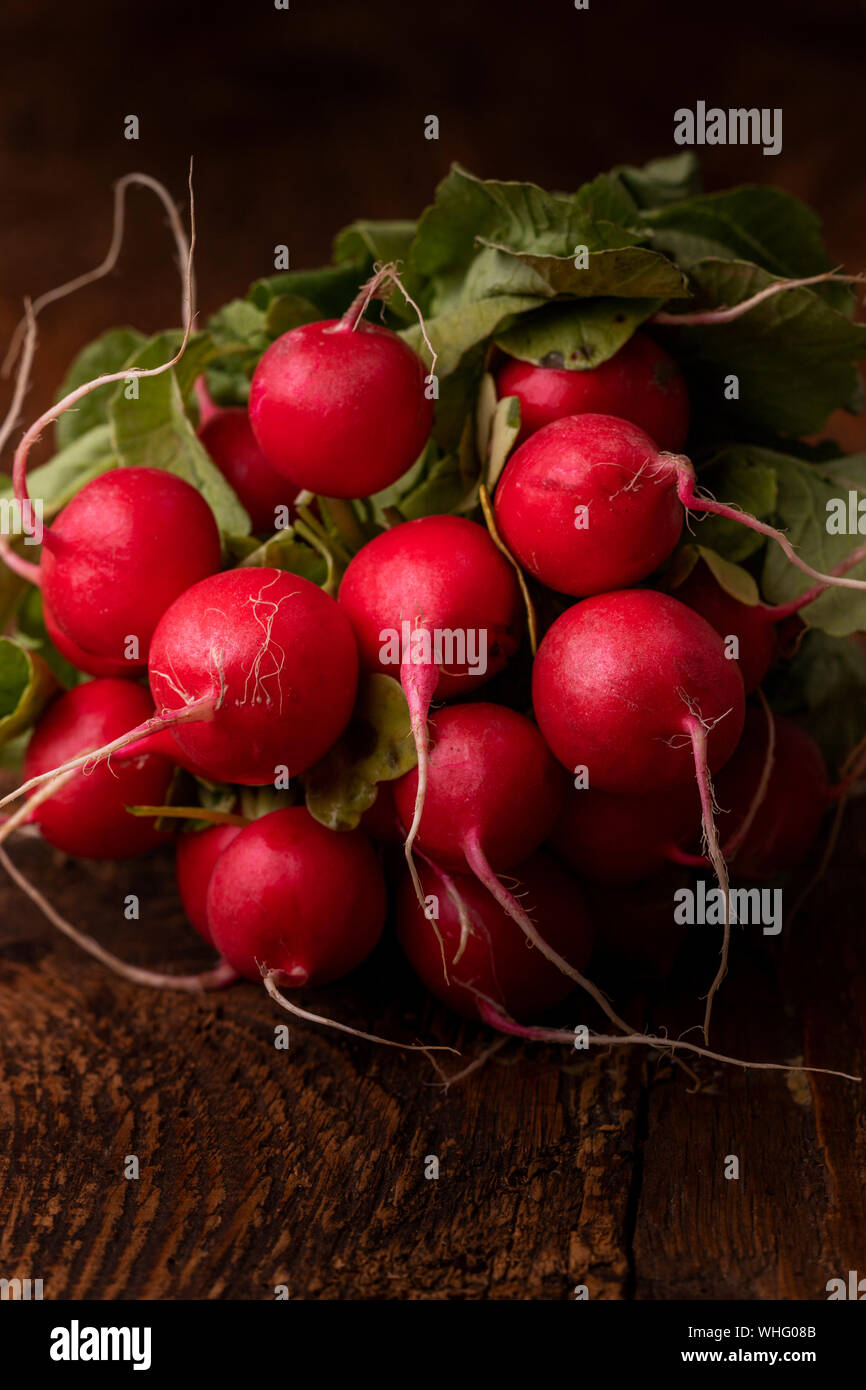 red radishes on dark wood Stock Photo - Alamy