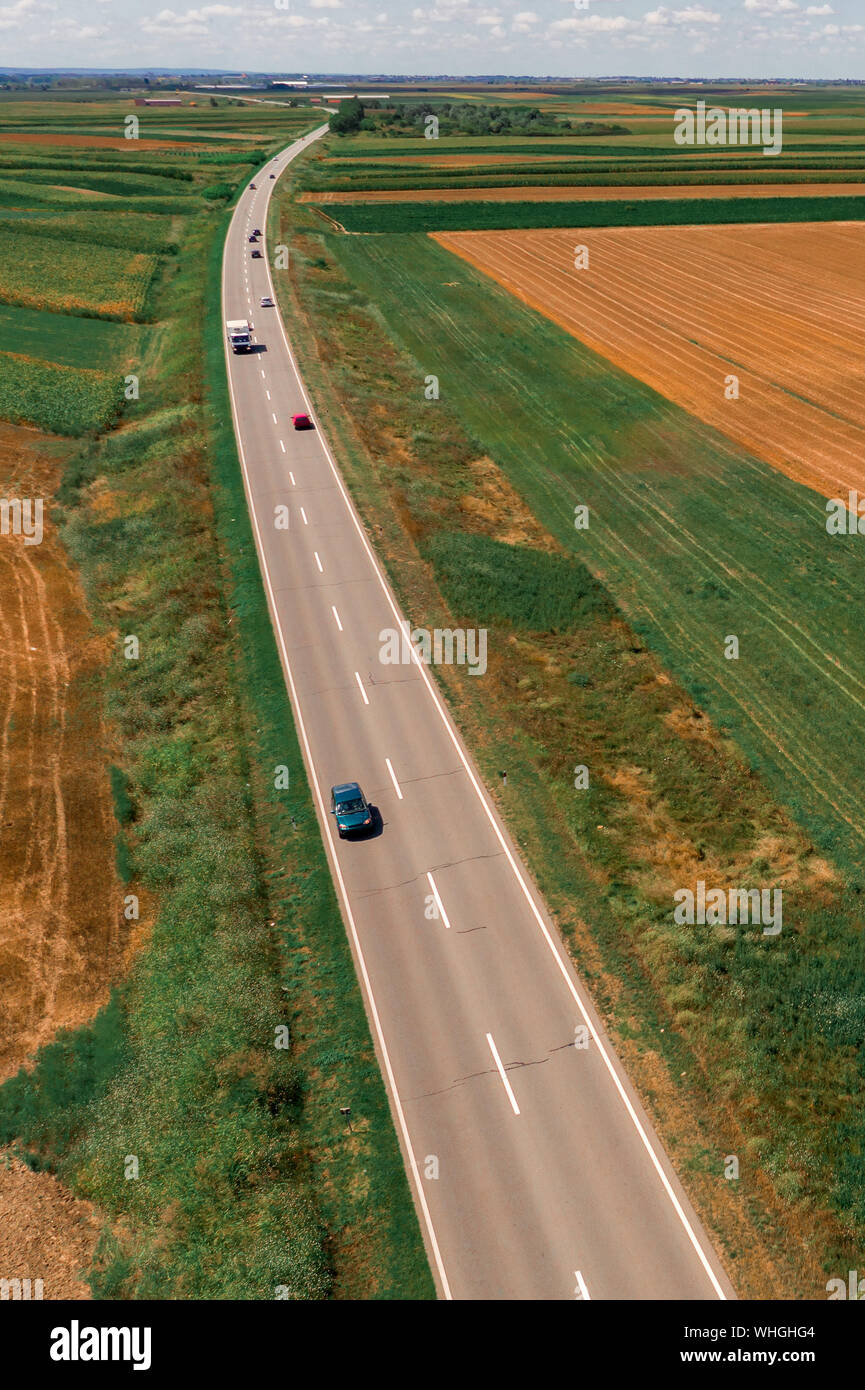 Traffic on the road through countryside landscape from drone pov ...