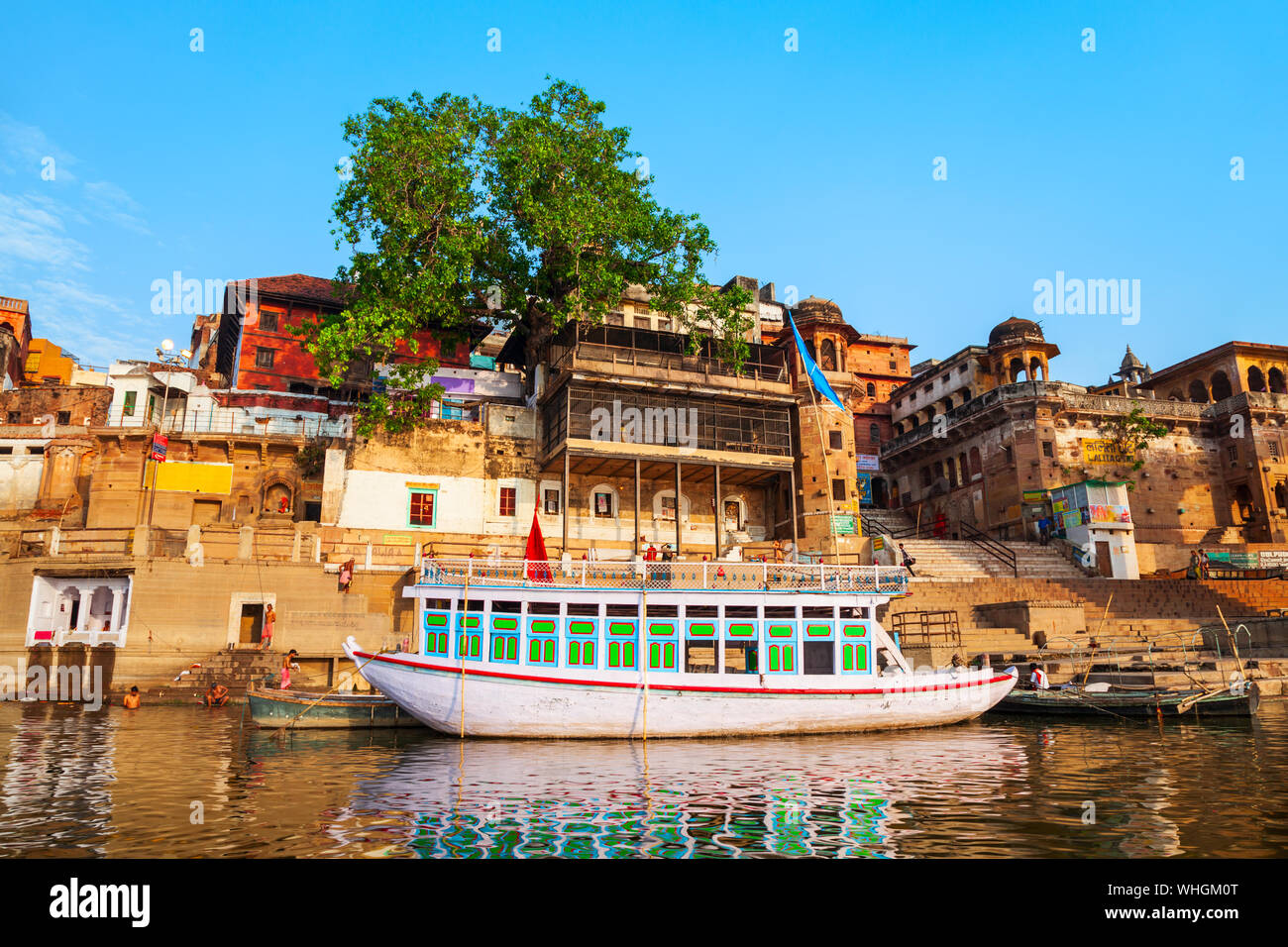 VARANASI, INDIA - APRIL 12, 2012: Colorful boats and Ganges river bank ...
