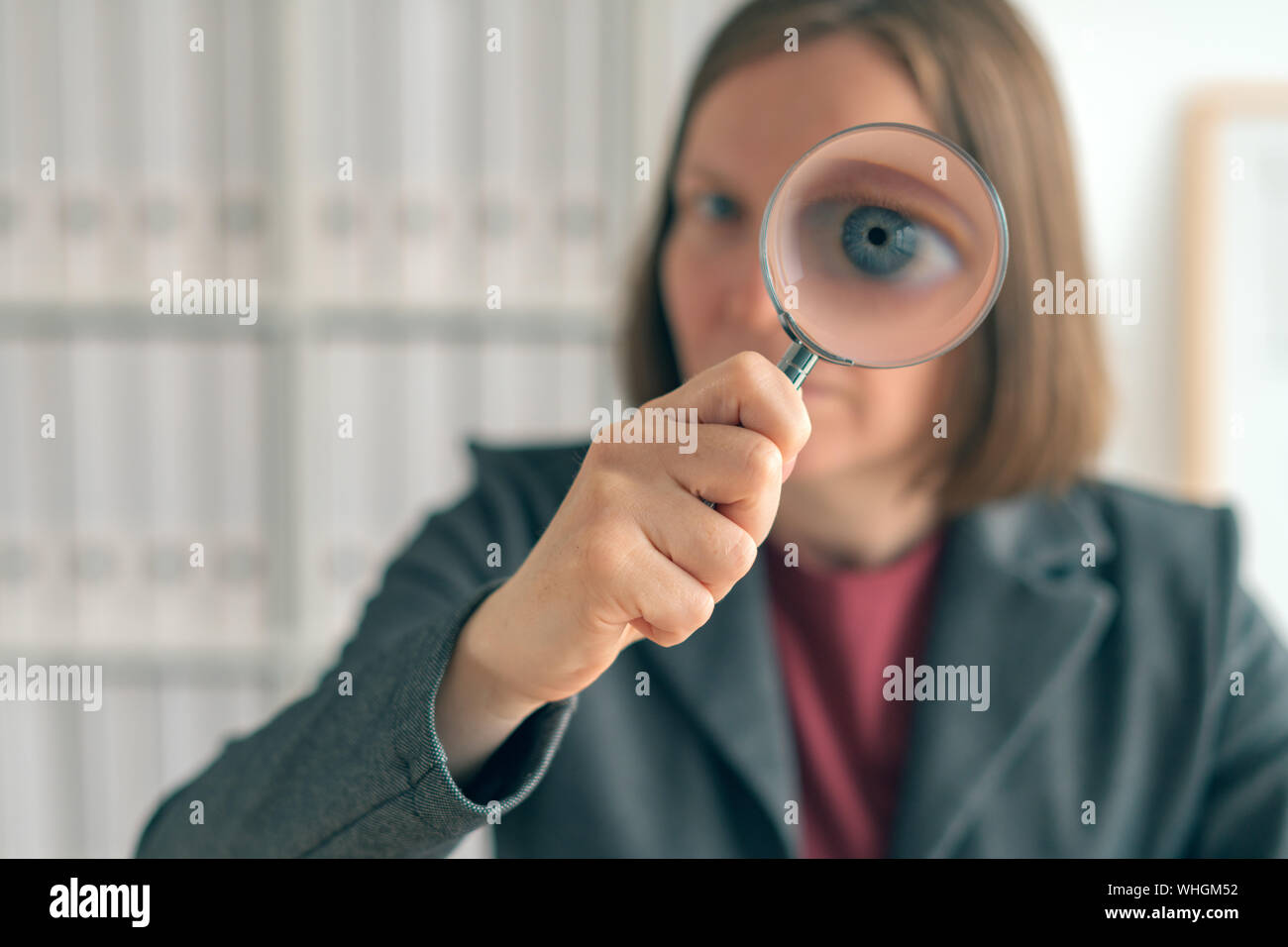 Businesswoman with magnifying glass doing business financial auditing ...