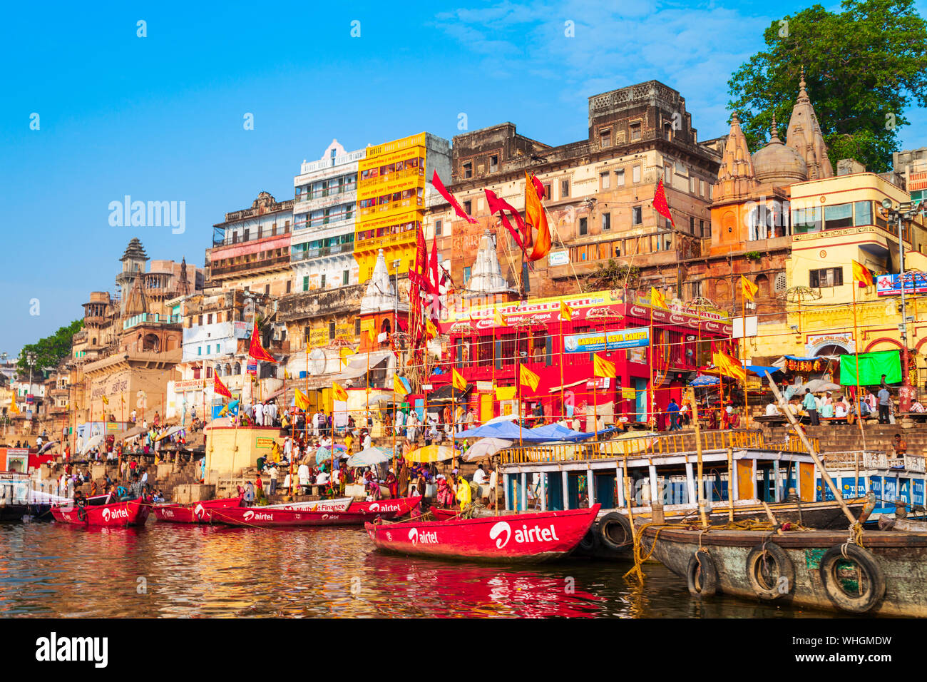 VARANASI, INDIA - APRIL 12, 2012: Colorful boats and Ganges river bank ...