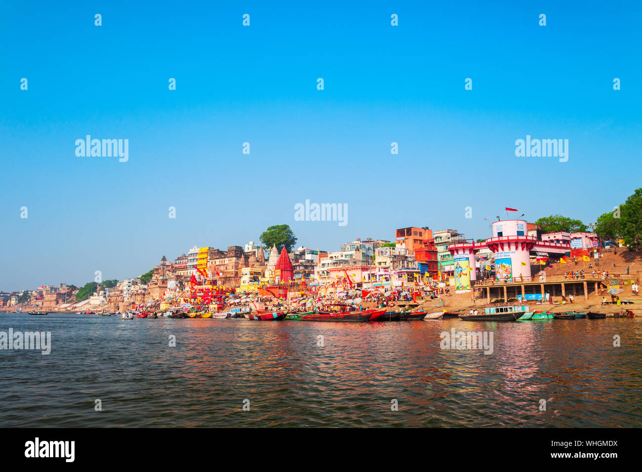 VARANASI, INDIA - APRIL 12, 2012: Colorful boats and Ganges river bank ...