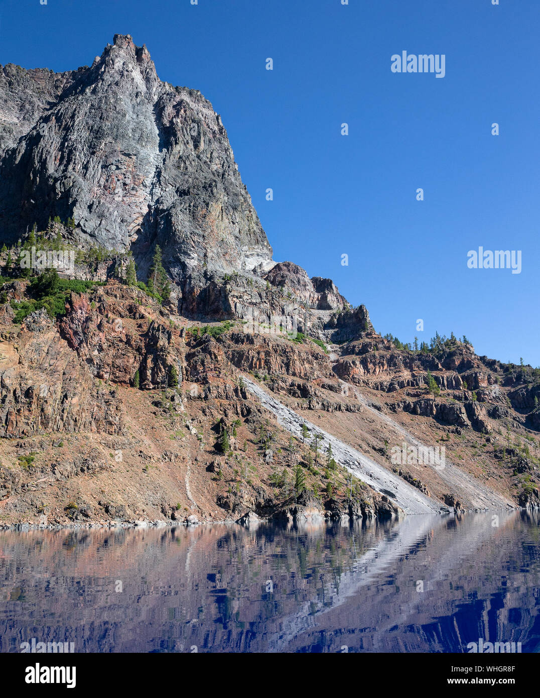 A view of Crater Lake rim reflected in its waters. The rim is doted by ...