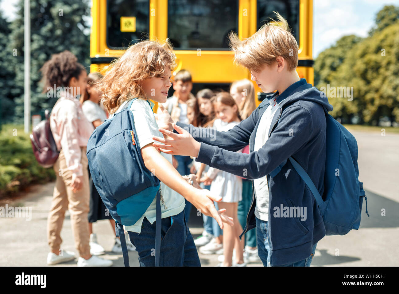 Group of children classmates going to school by bus boy pushing his ...