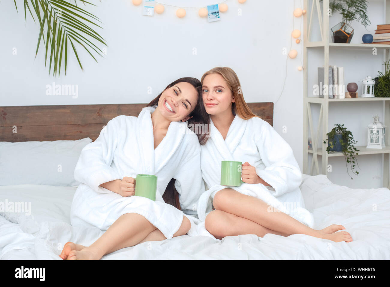 Young women rest together at home beauty care wearing bath robes ...