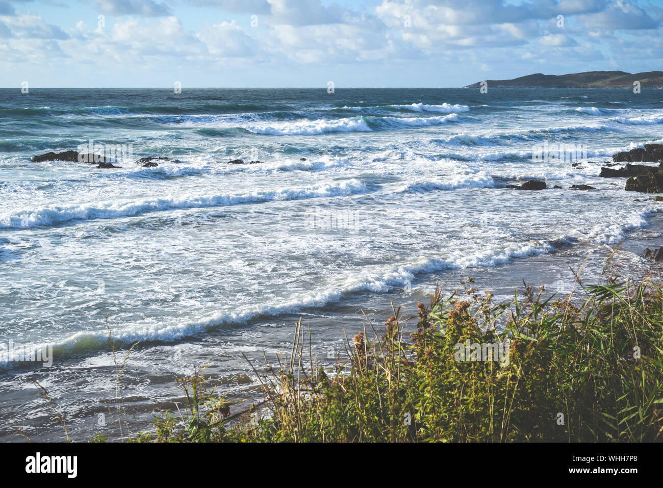 Waves breaking on the beach at high tide on the shore in North Devon UK ...
