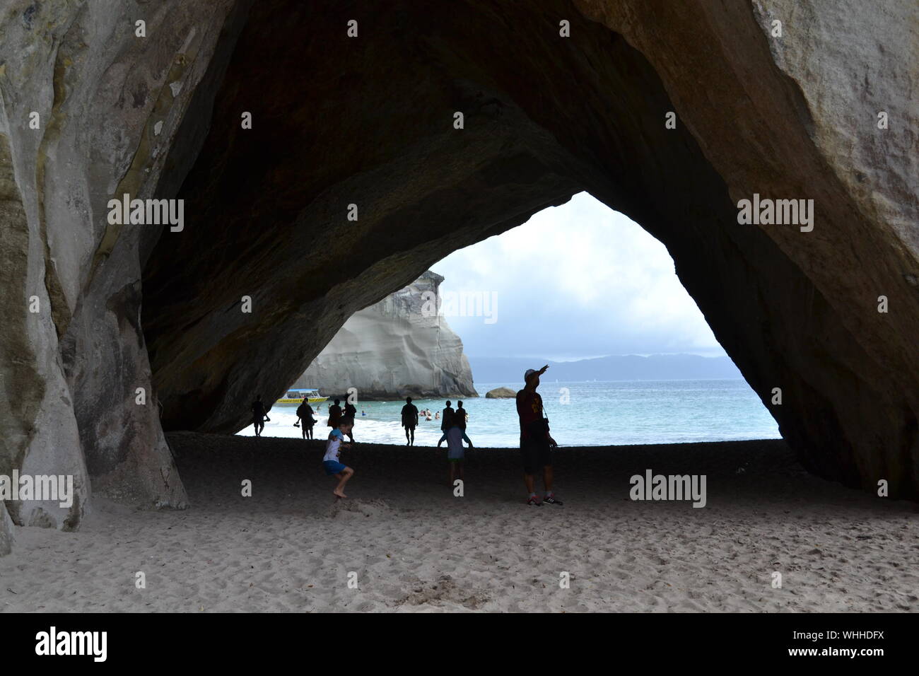 People Below Rock Formation At Beach Stock Photo - Alamy
