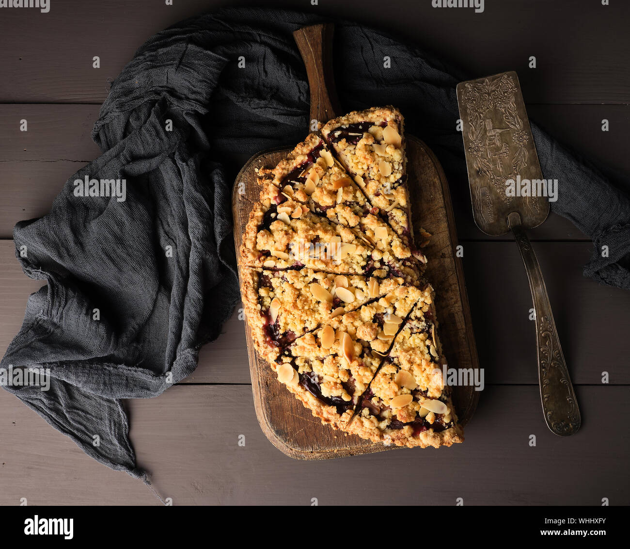 half plum pie crumble on a brown wooden cutting board, top view Stock ...