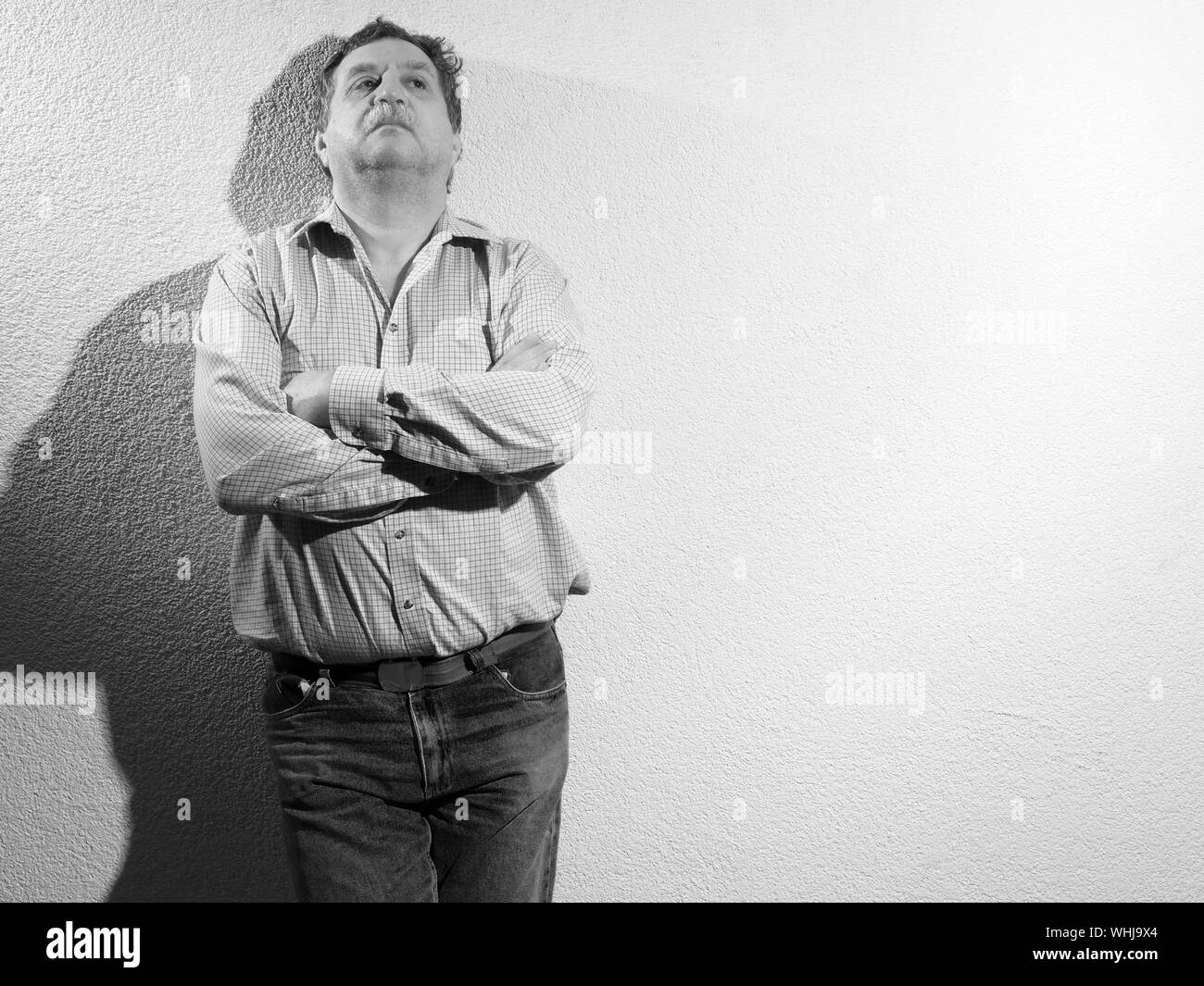 Old man leaning against wall Black and White Stock Photos & Images - Alamy