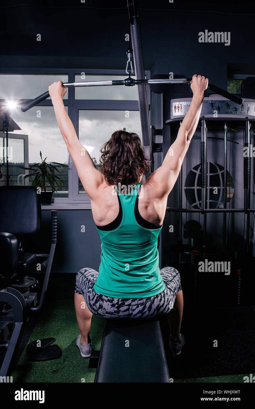 A back view of a trained girl doing exercises. Training for back ...