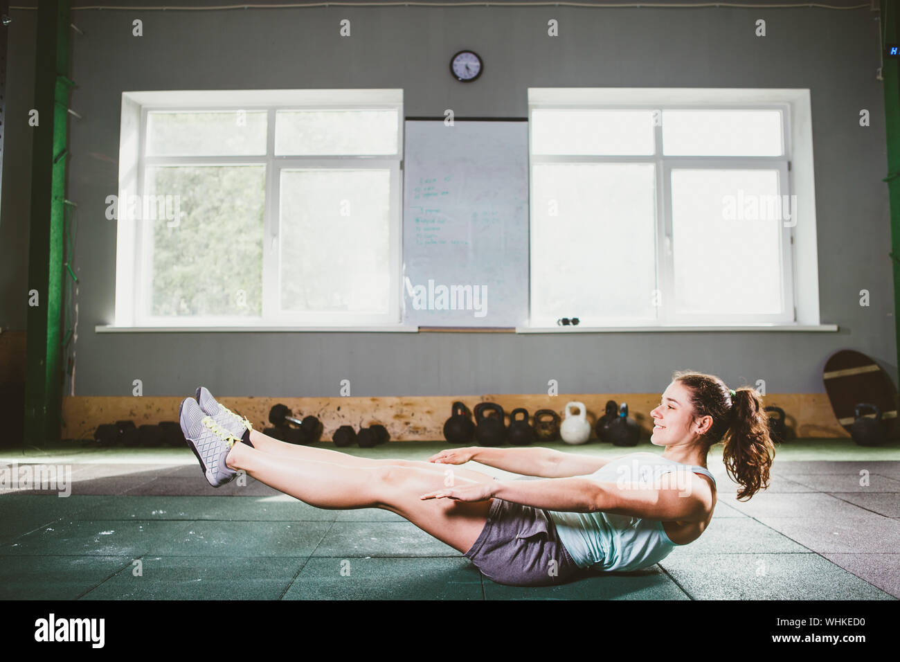 young and strong girl with a smile doing exercises for the muscles of ...
