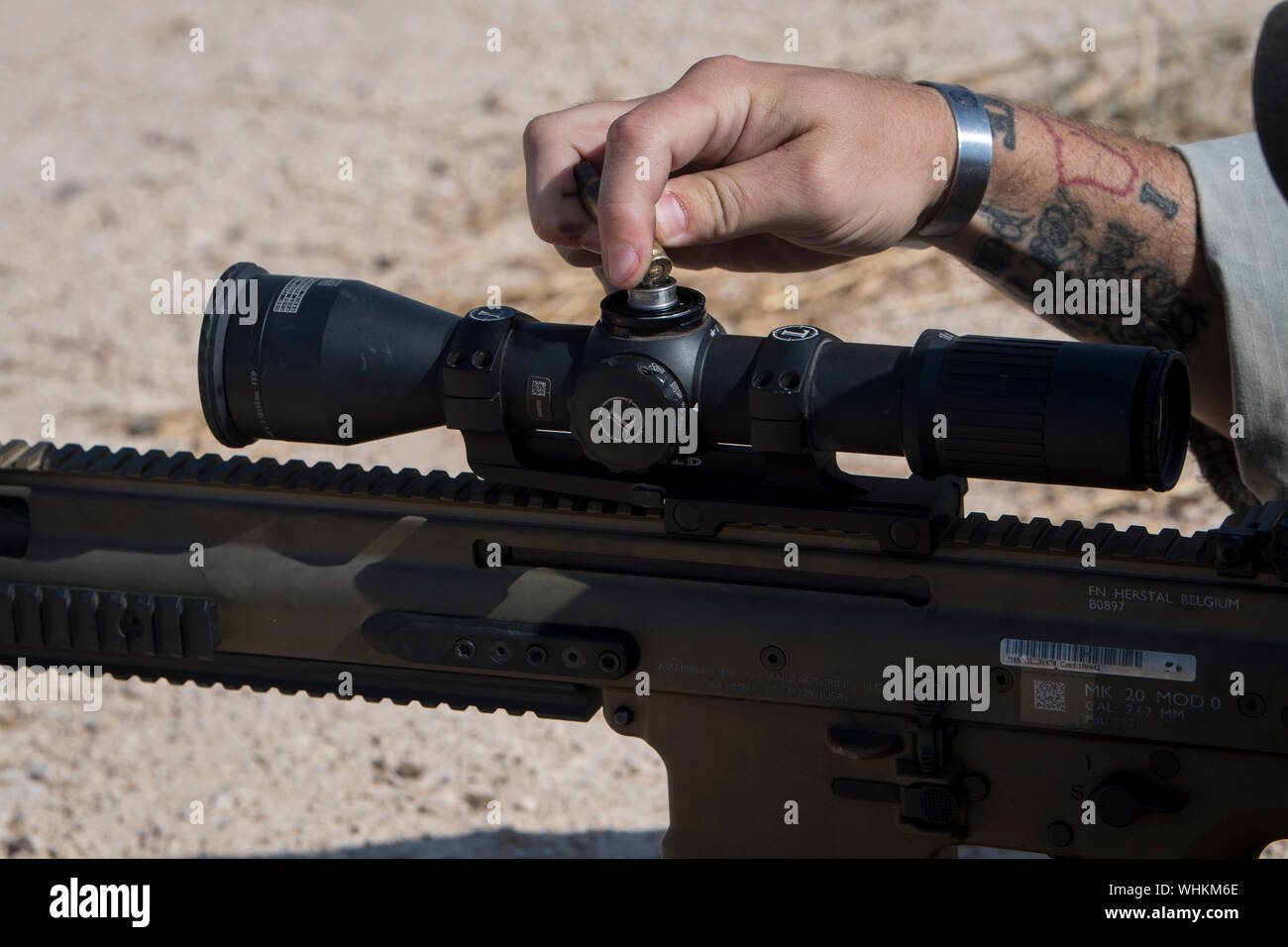 A U.S. Air Force Special Tactics Operator adjusts the sights of a scope ...
